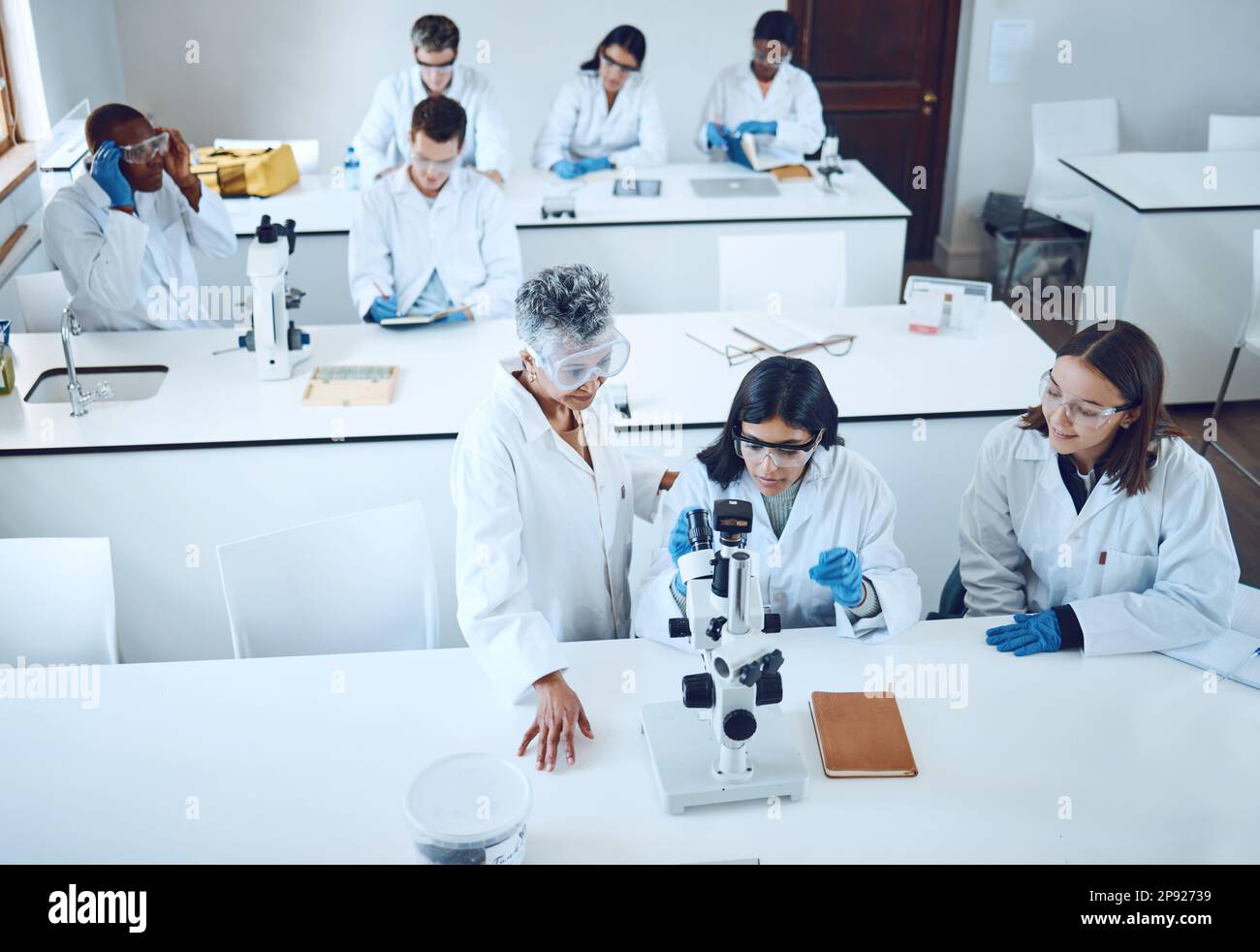 Science, university students and microscope in scientist lab for ...