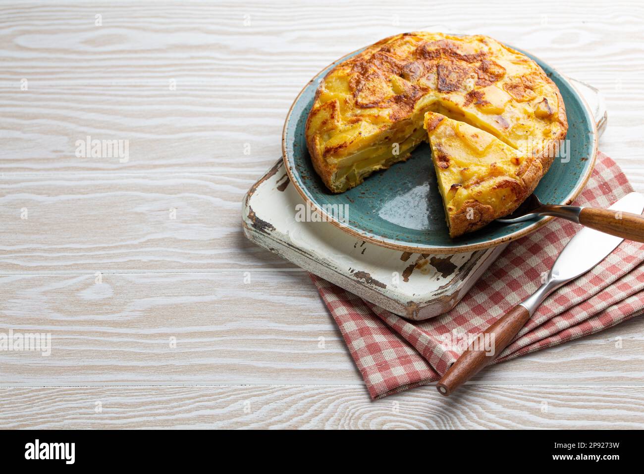 Homemade Spanish tortilla with one slice cut - omelette with potatoes ...