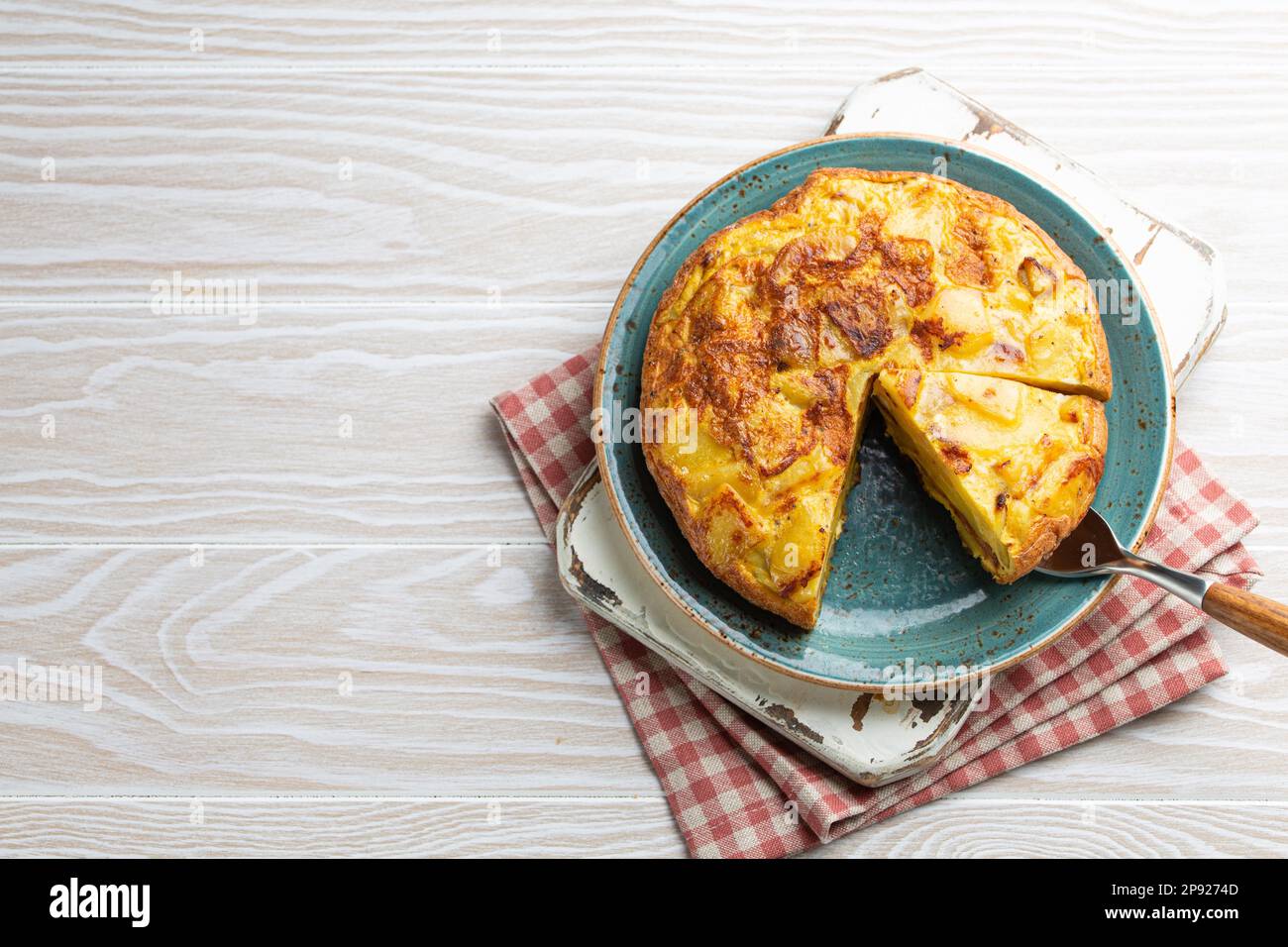 Homemade Spanish tortilla with one slice cut - omelette with potatoes ...