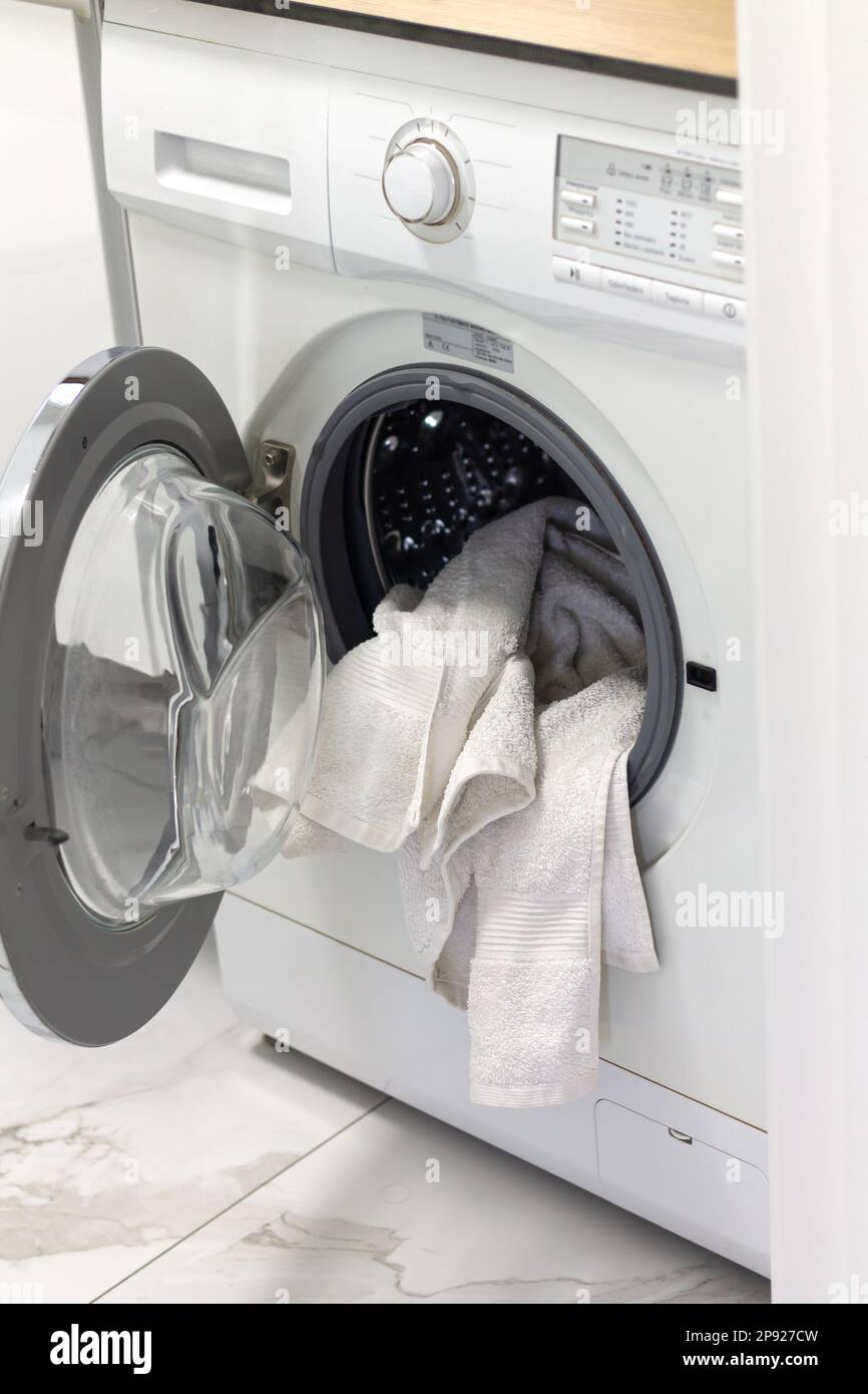Open washing machine or clothes dryer with washed and dried white ...