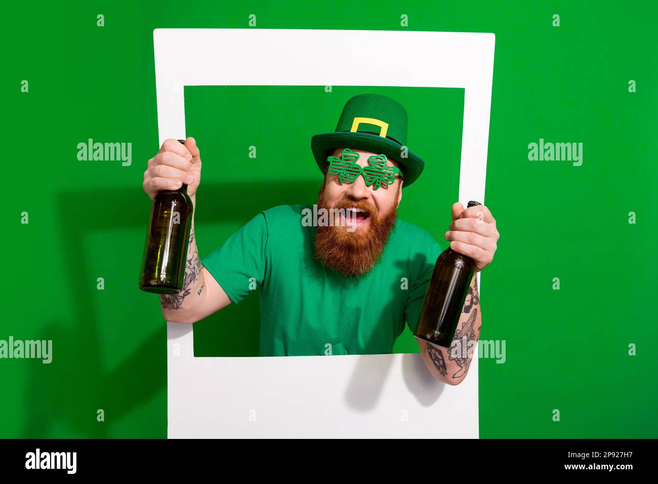 Photo of handsome cool man wear t-shirt drinking ale enjoying shamrock ...