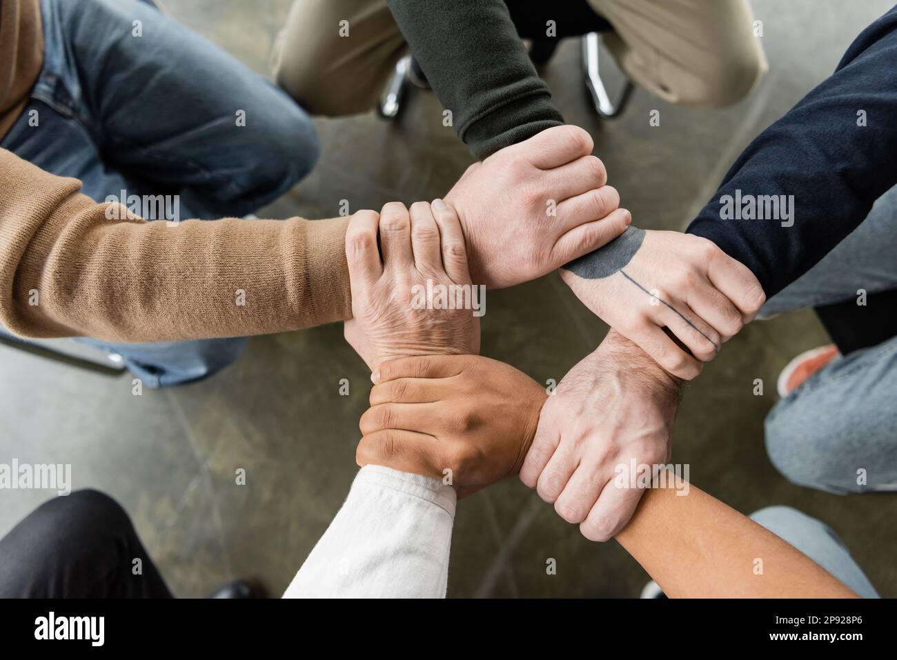 Top view of multiethnic people with alcohol addiction joining hands ...
