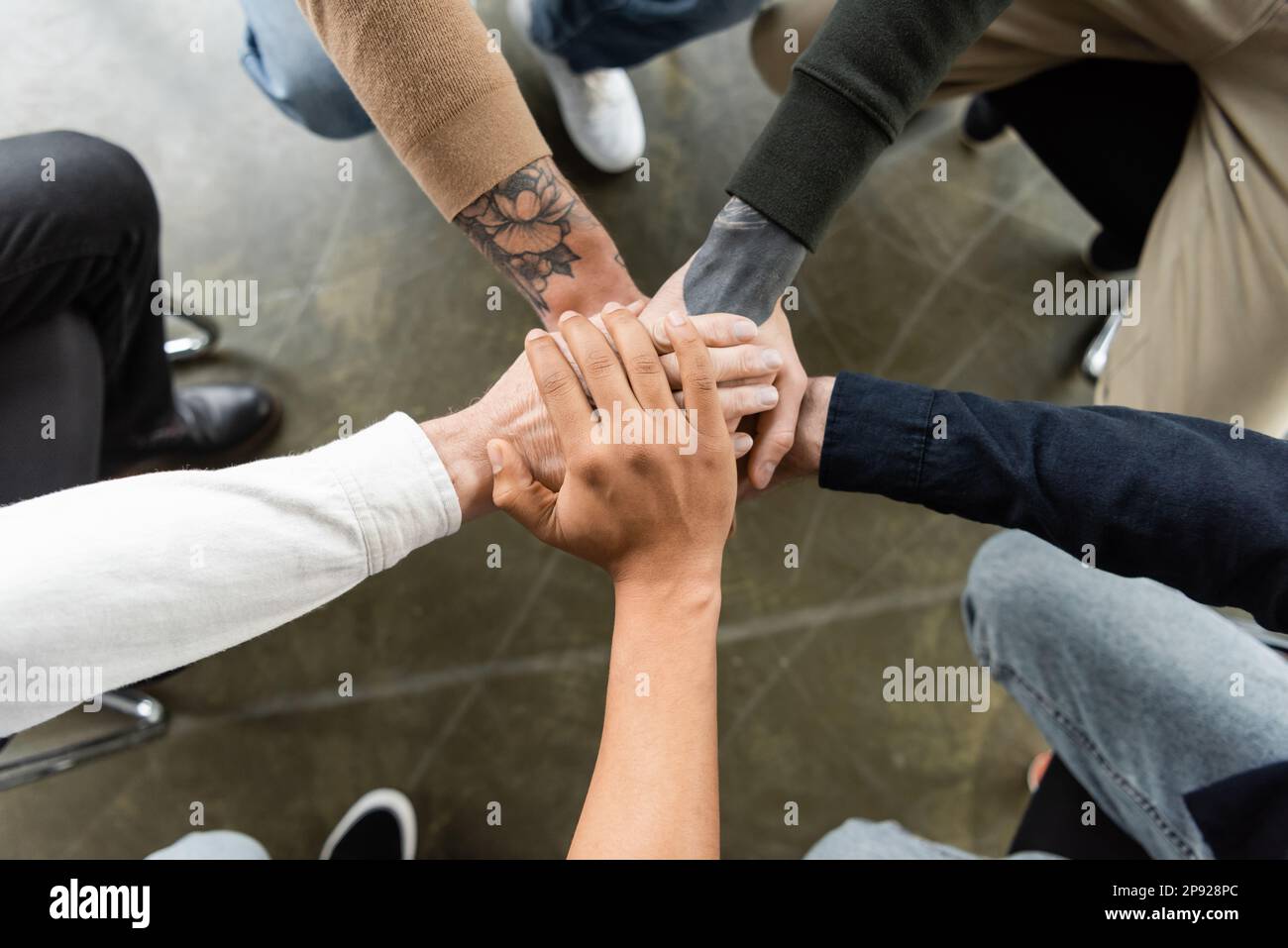 Top view of multiethnic people holding hands together during anonymous ...