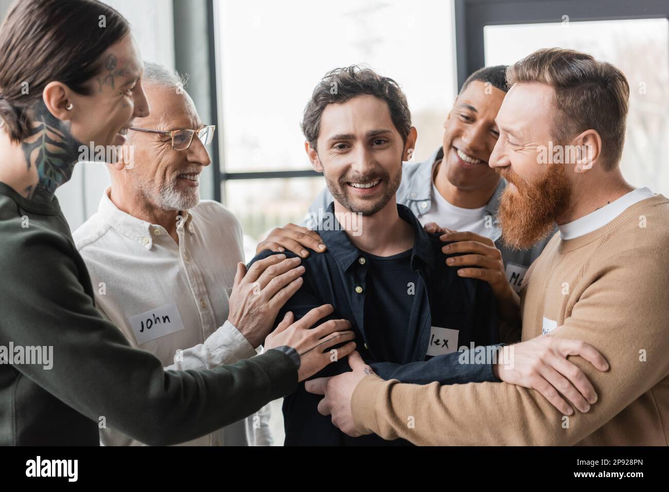Multiethnic people hugging smiling man with alcohol addiction during ...