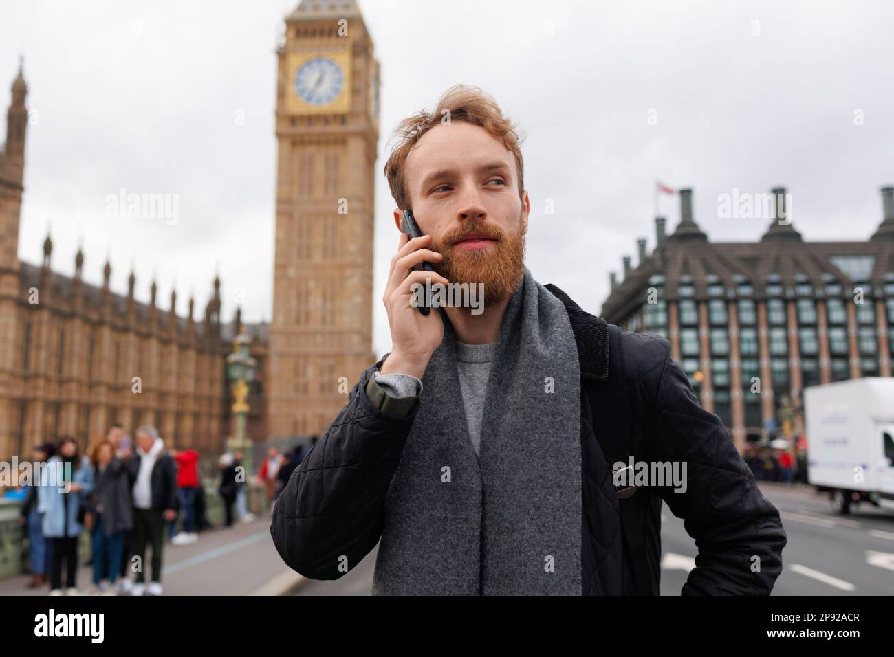 Man talks on a mobile phone while standing near Big Ben in London Stock ...