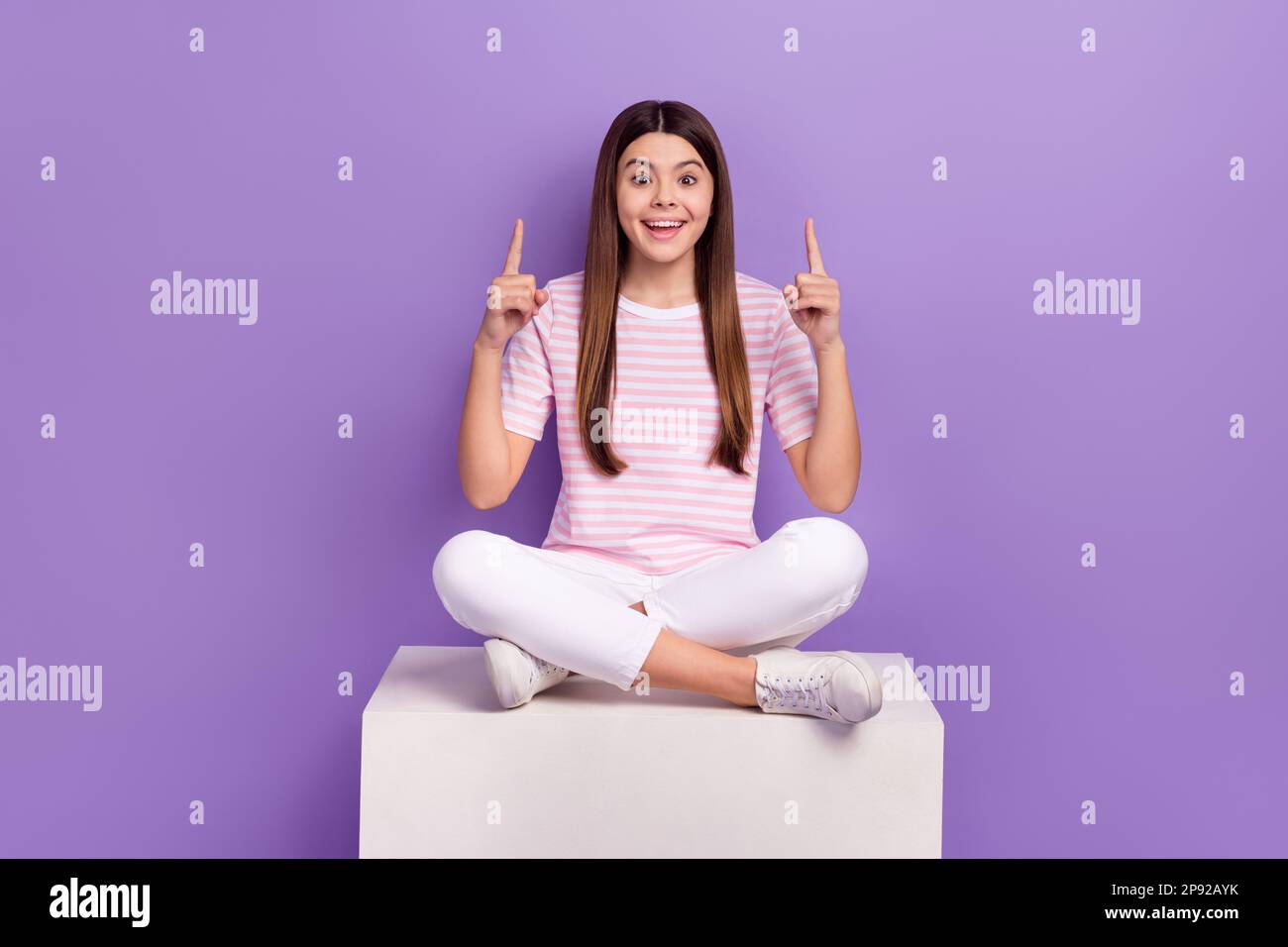 Full size photo of astonished cheerful girl sit podium direct fingers ...