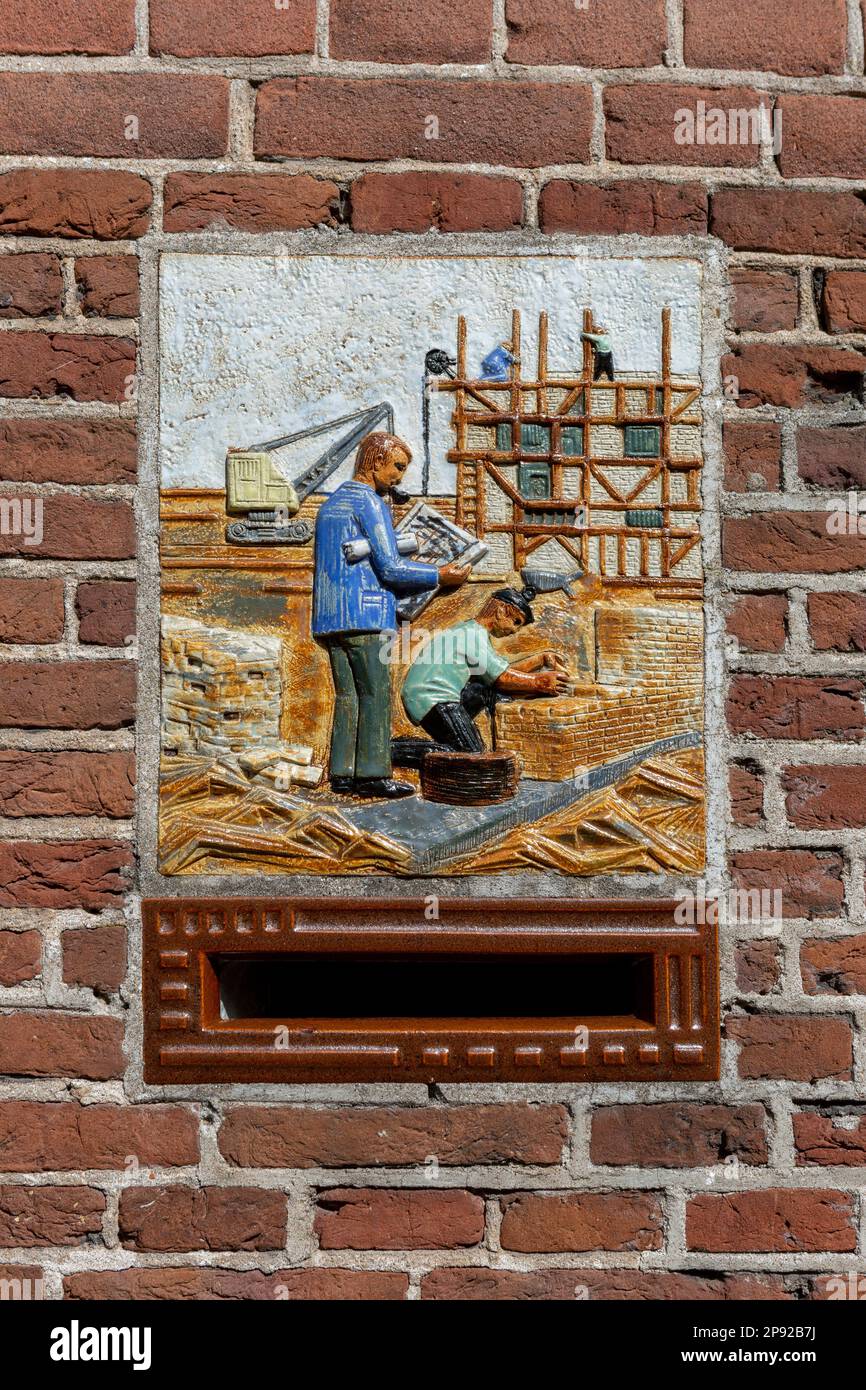 Red brick wall decoration with depiction of Dutch bricklayer and ...