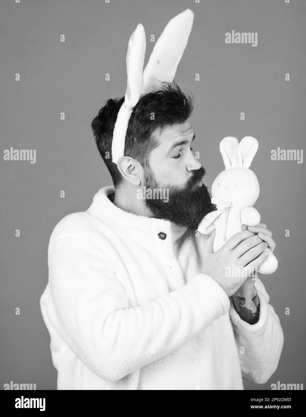 My cute bunny. Bearded man in easter rabbit costume holding hare toy. Happy man with rabbit ears ...