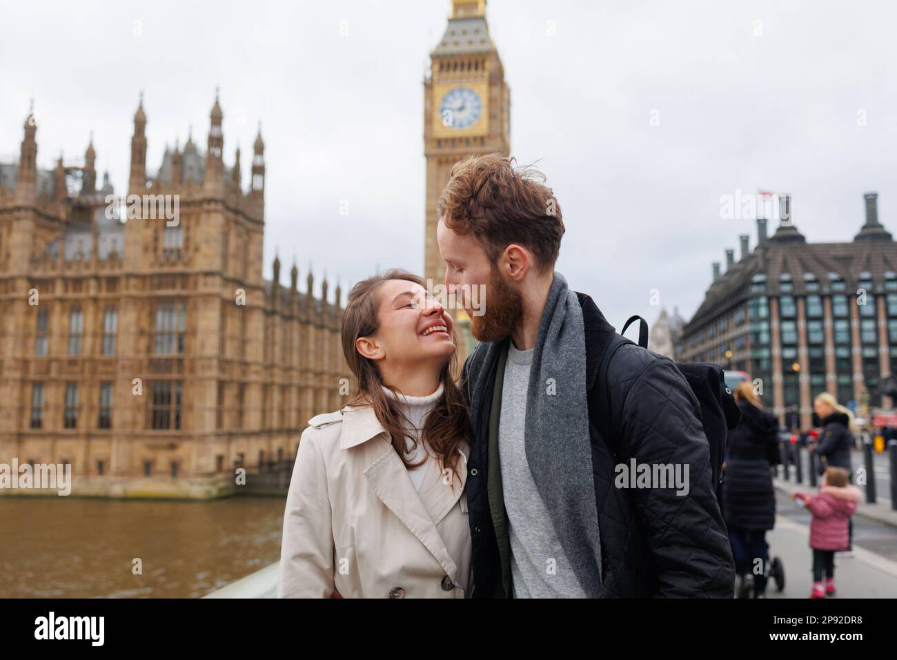 Young couple is kissing against the background of the Big Ben tower in ...