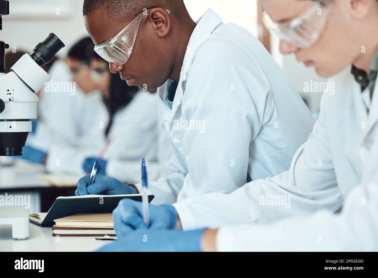 Science students, research and writing in laboratory, experiment and ...