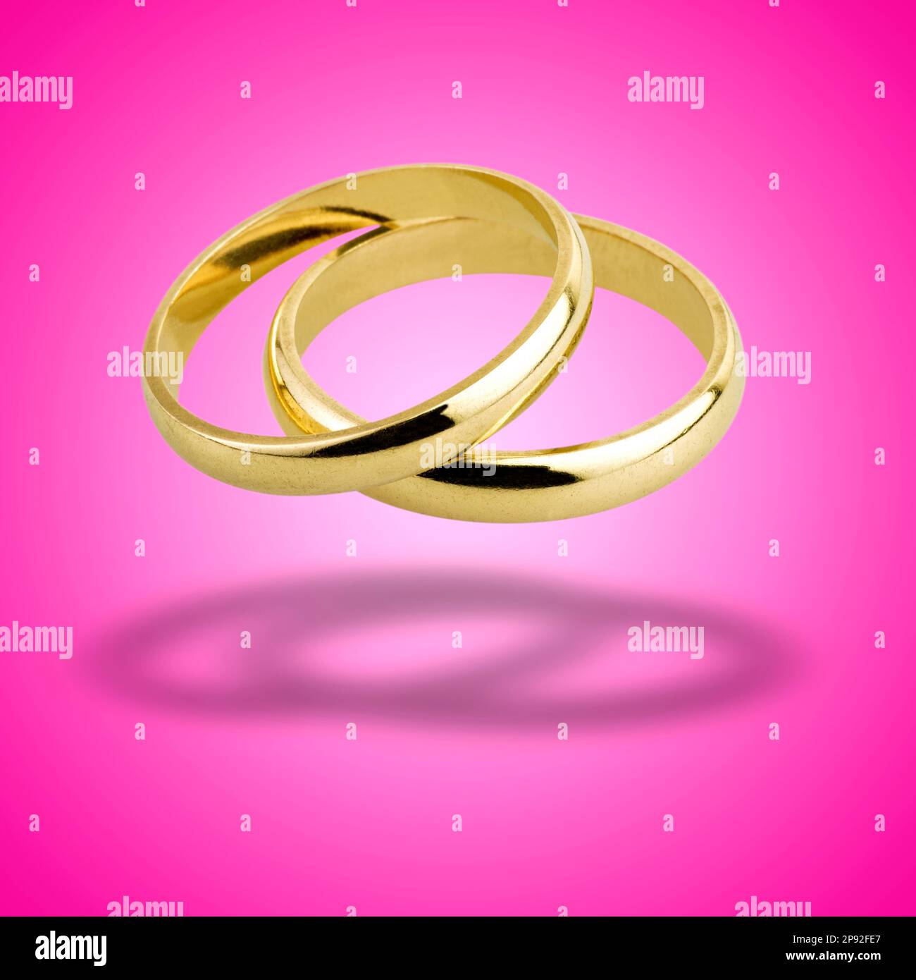 old wedding rings floating against pink radial background Stock Photo ...