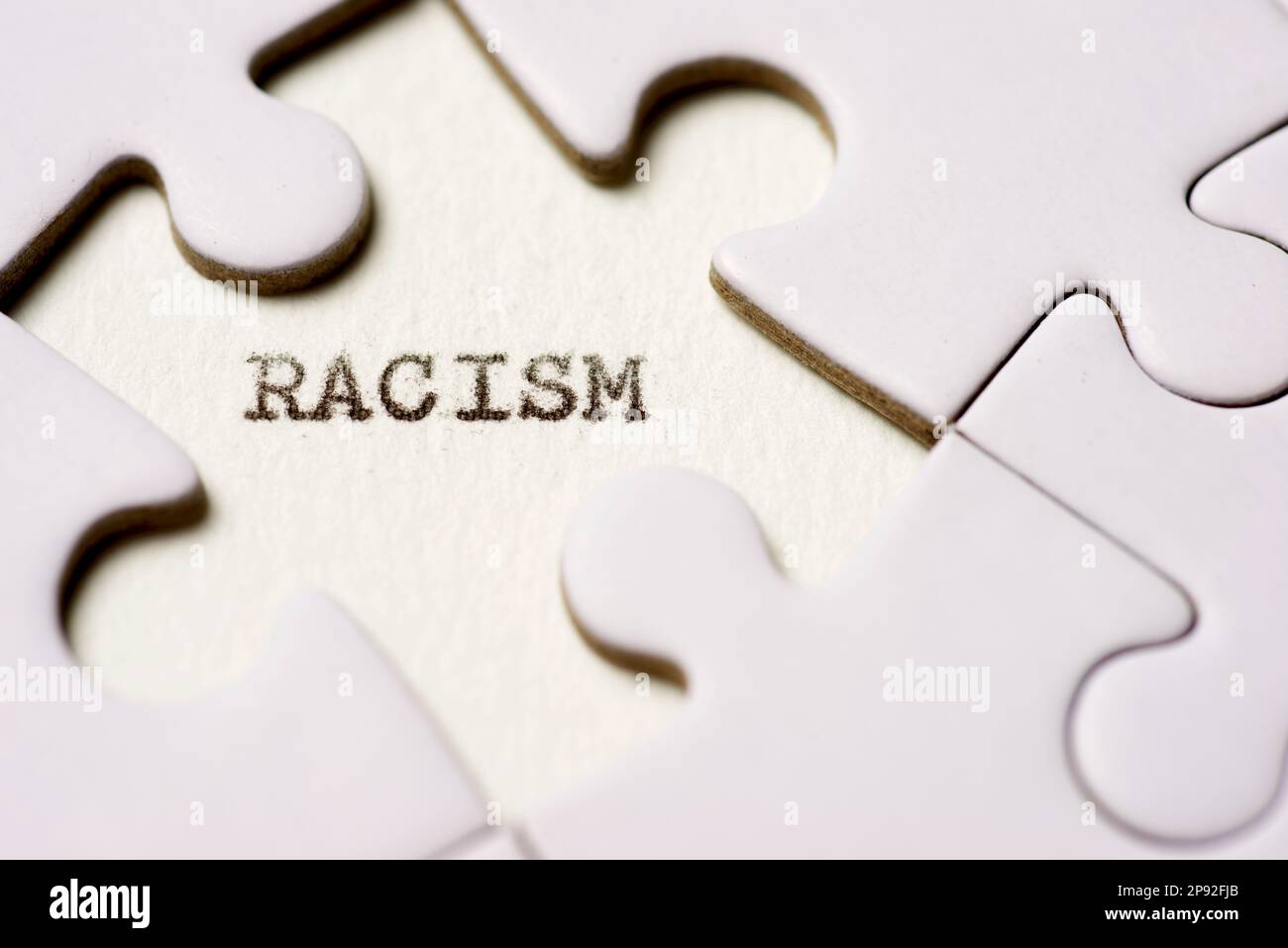 Racism text written with a typewriter in a white puzzle Stock Photo - Alamy