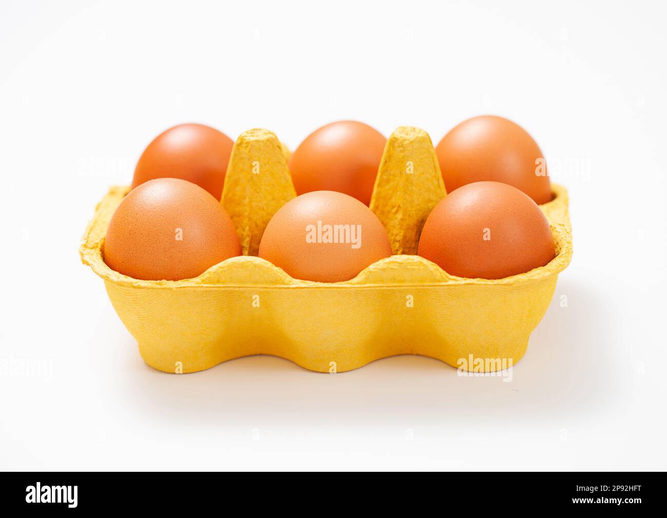 Brown raw organic eggs in yellow paper tray on white Stock Photo - Alamy