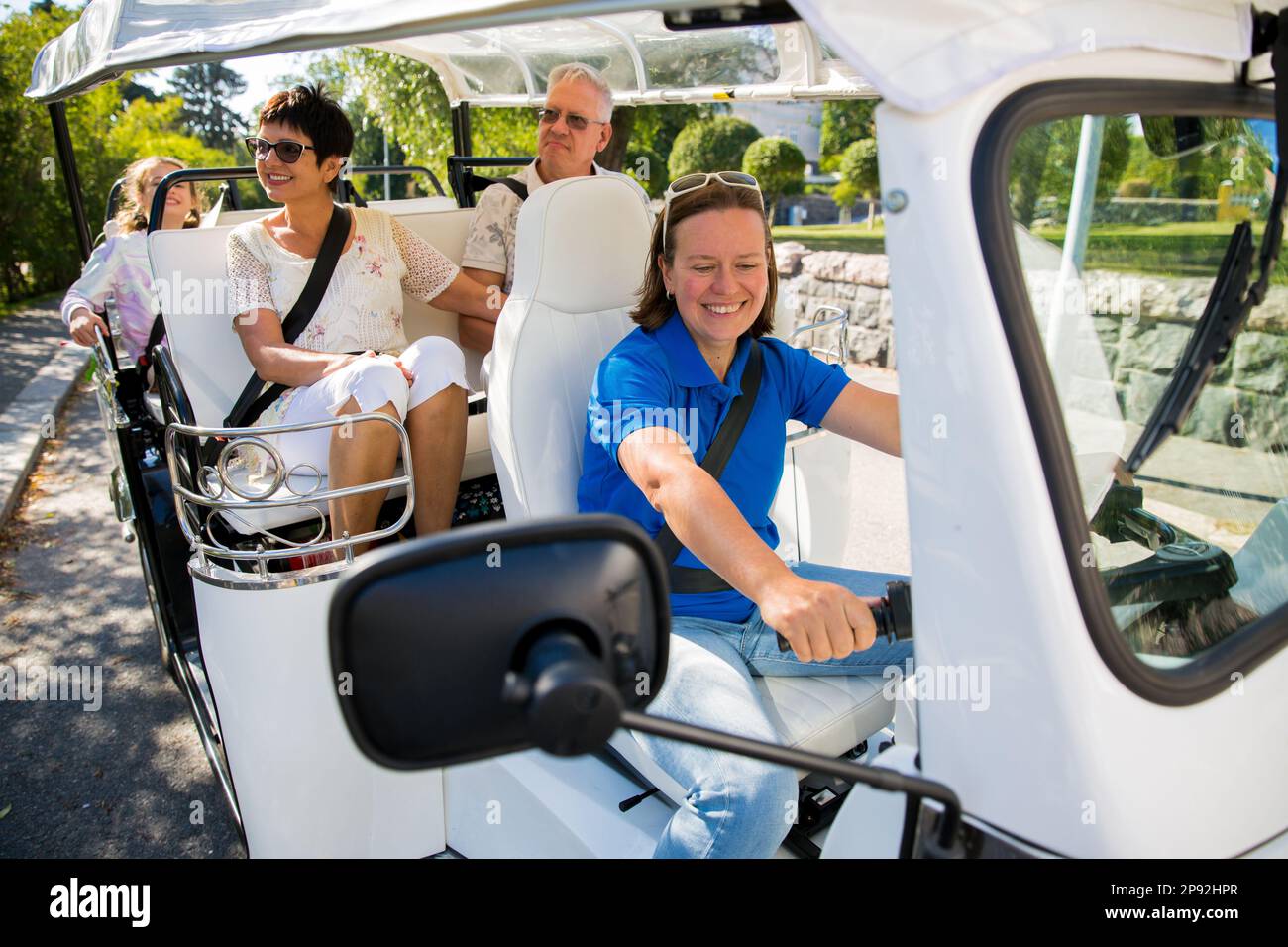 A group of tourists driving through the city center in tuk-tuk electric ...