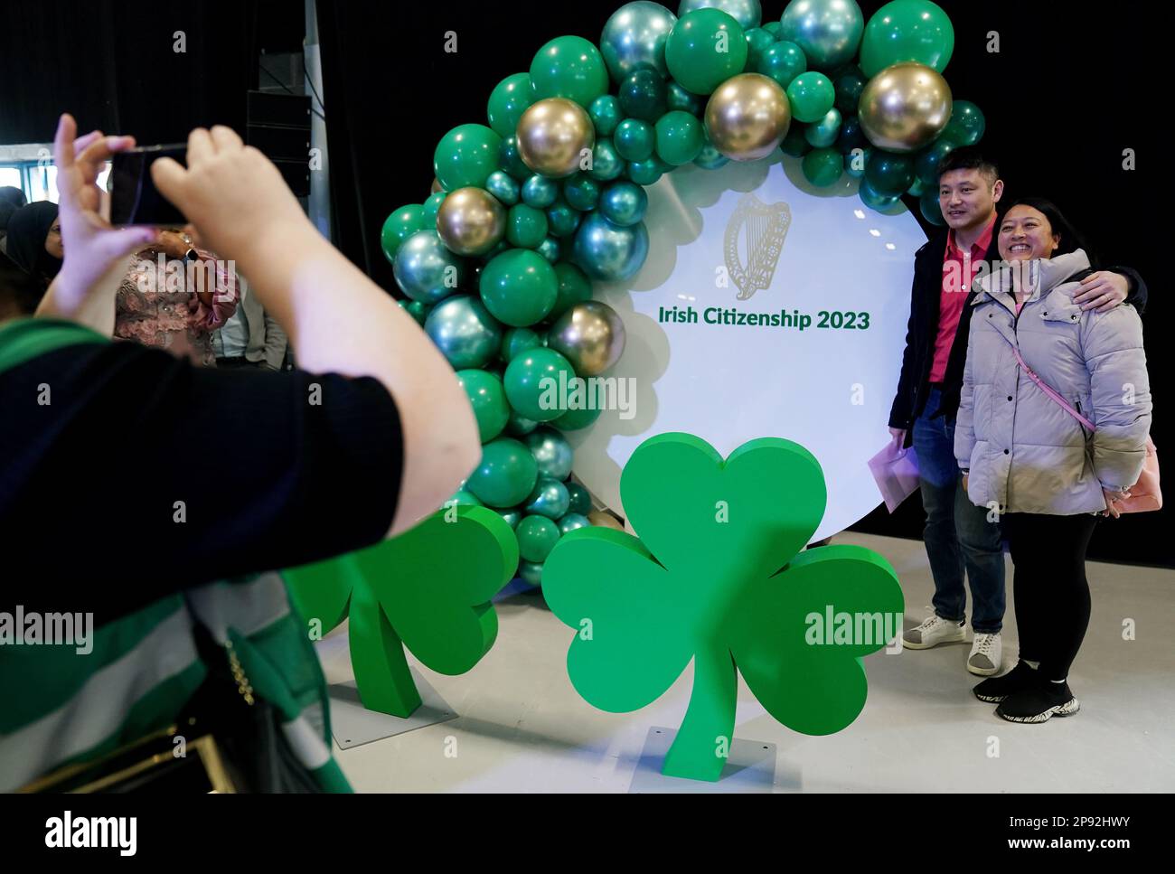 People pose for photographs following a Citizenship Ceremony at the RDS ...