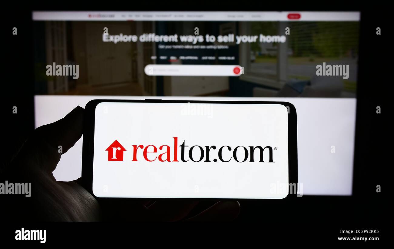 Person holding mobile phone with logo of US real estate platform ...