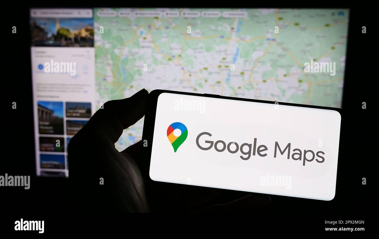 Person holding mobile phone with logo of web mapping platform Google ...
