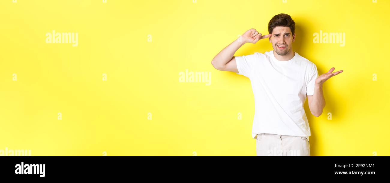 Confused and angry man pointing at head, scolding person for acting ...
