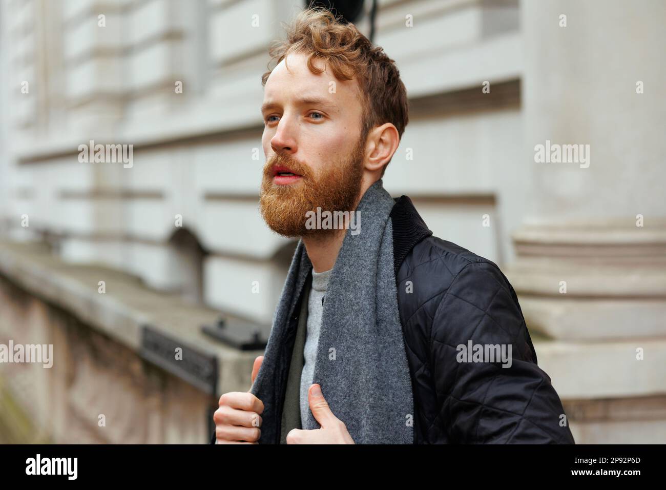 Portrait of a stylish brutal man with a beard posing on a city street ...