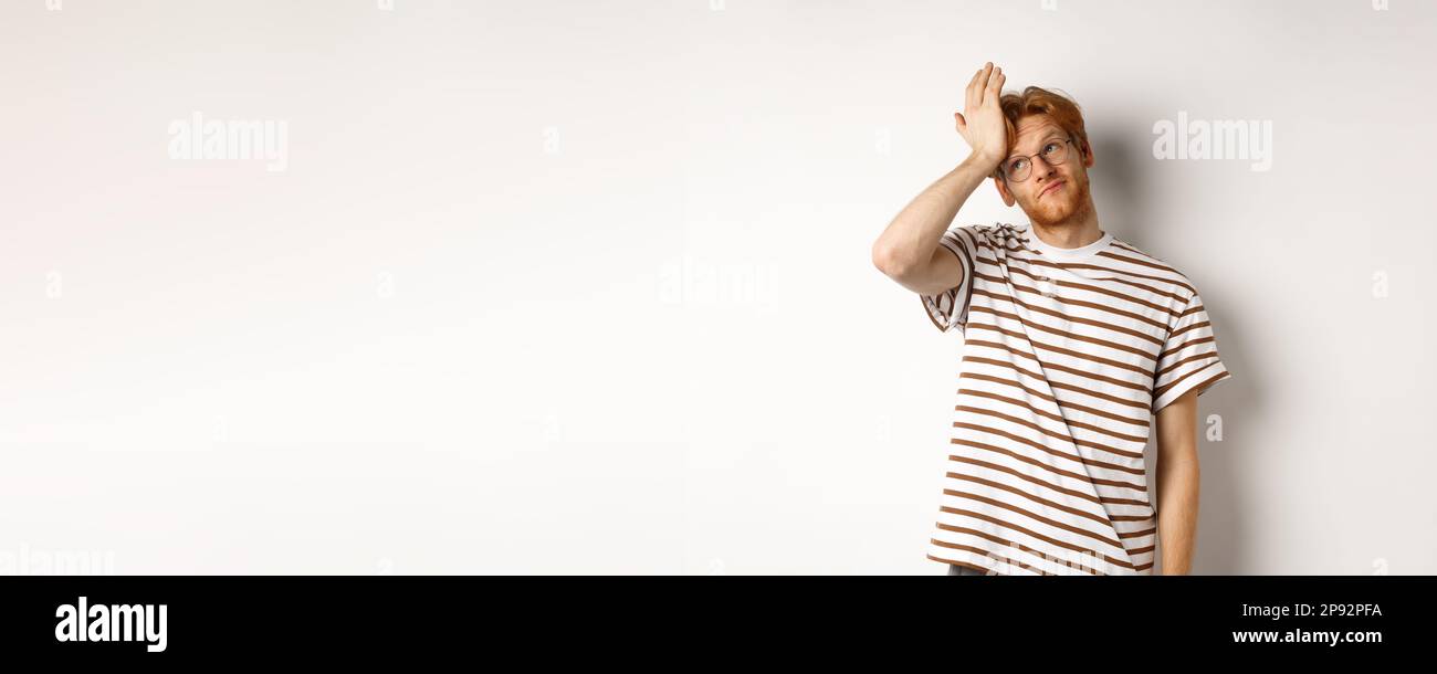 Tired young man with red hair and glasses, roll eyes and making ...