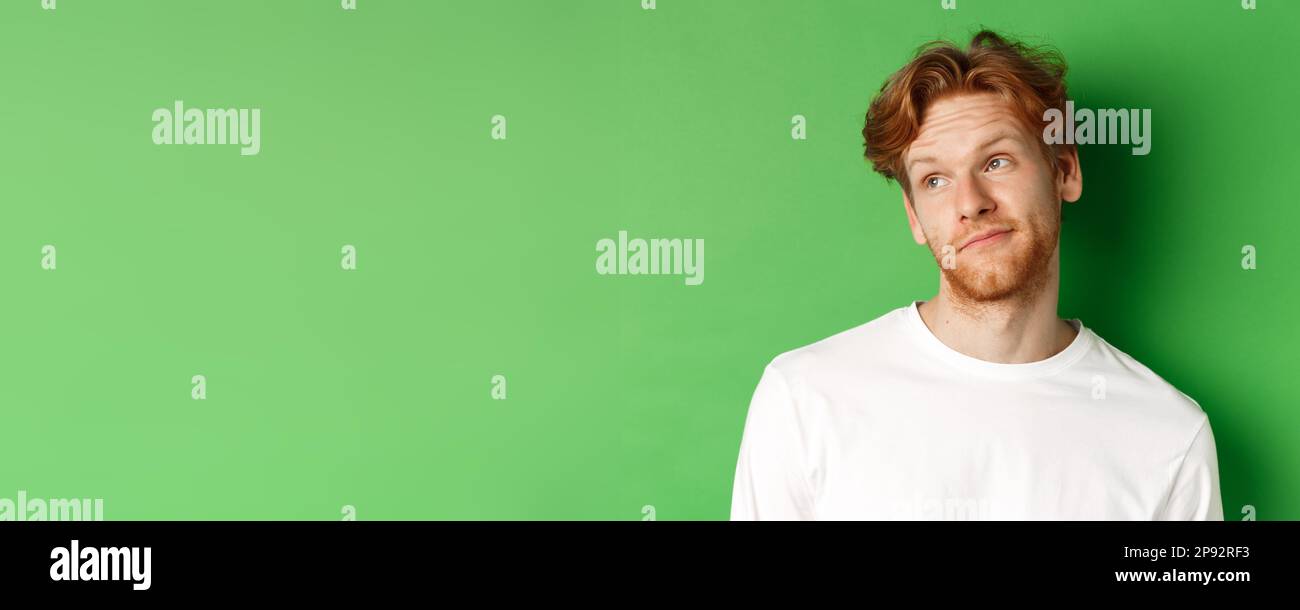 Smiling redhead man with messy haircut and beard tilt head, looking ...
