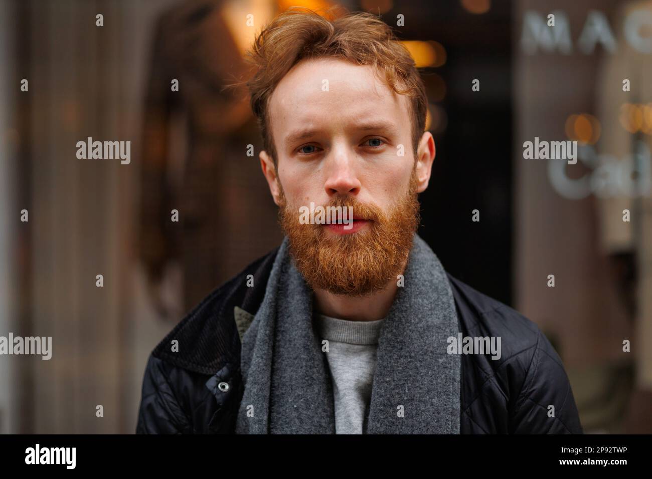 Portrait of a stylish bearded man against the backdrop of a clothing ...