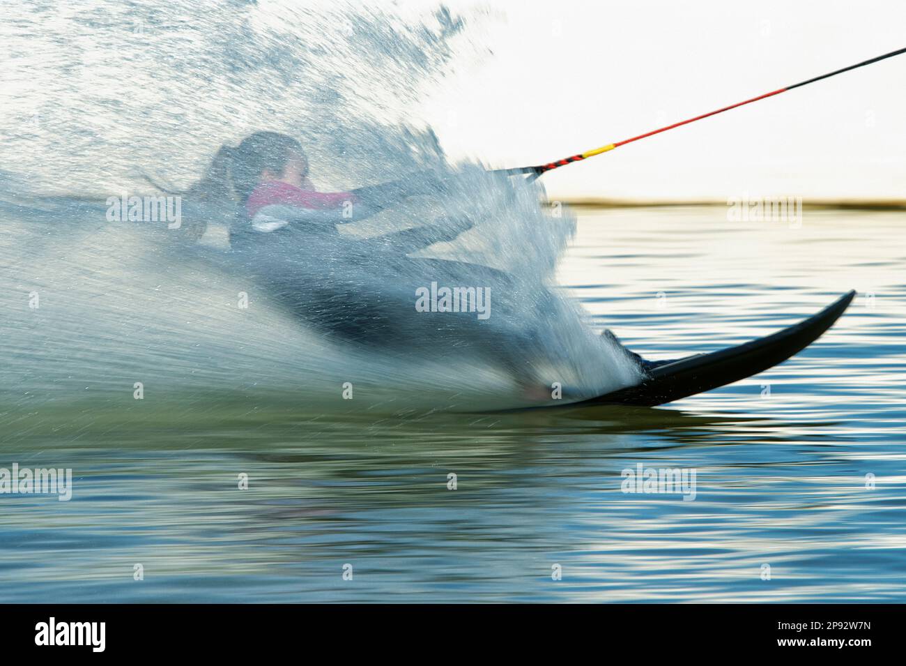 Fast female wakeboarder inside a cloud of water spray Stock Photo - Alamy