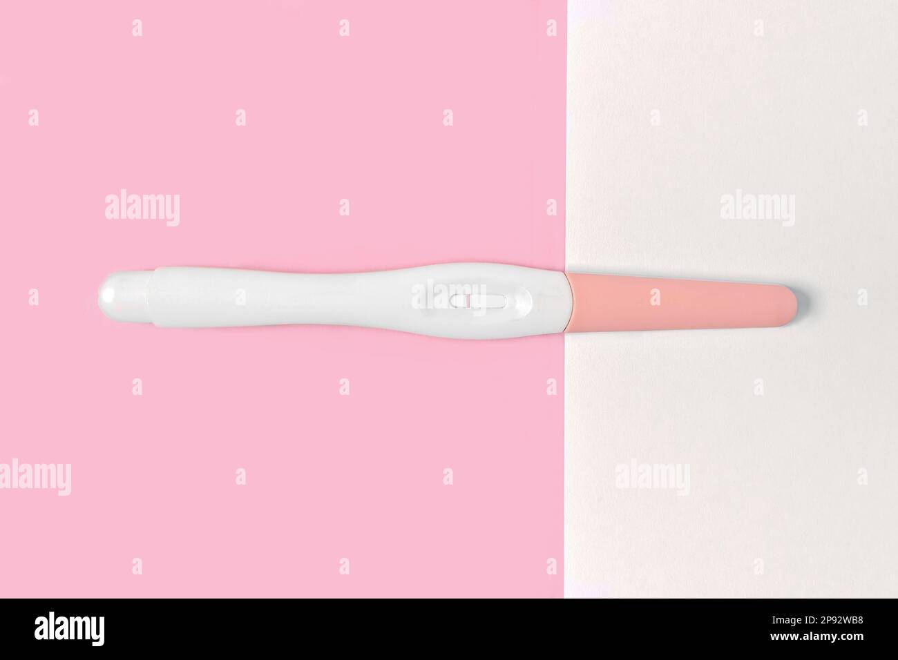 Negative plastic pregnancy test on pink and white background Stock ...