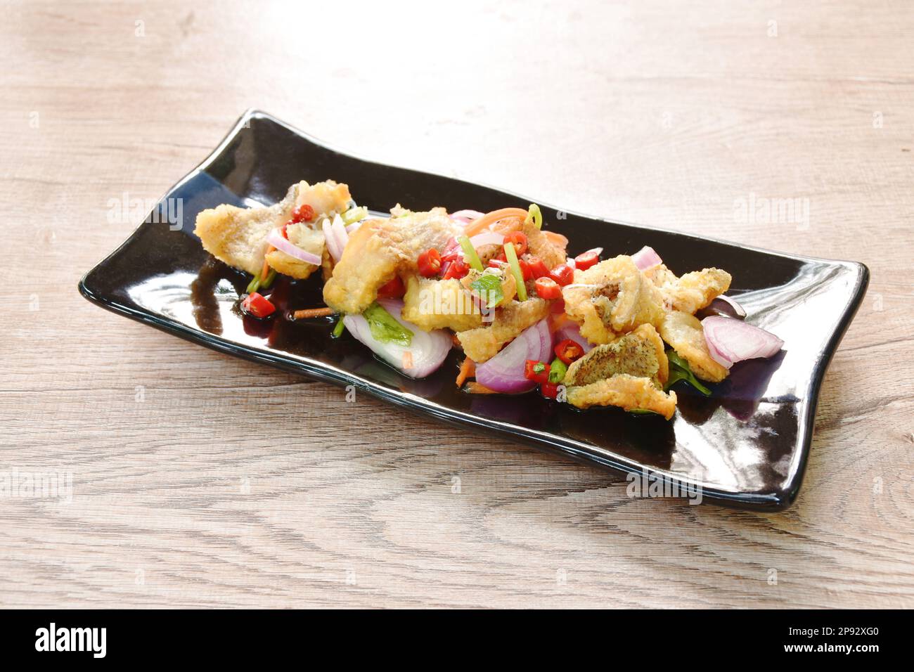 deep fried slice snake skin gourami spicy and sour Thai salad on plate ...