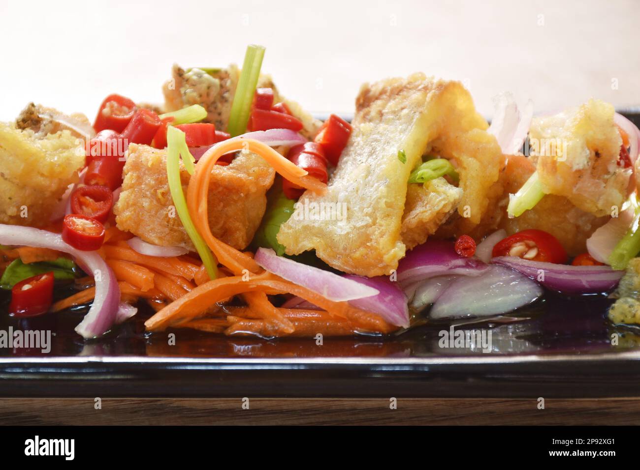 deep fried slice snake skin gourami spicy and sour Thai salad on plate ...