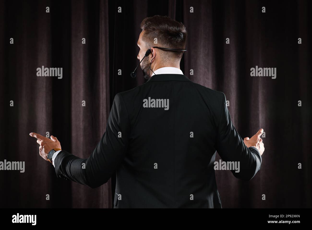 Motivational speaker with headset performing on stage, back view Stock ...