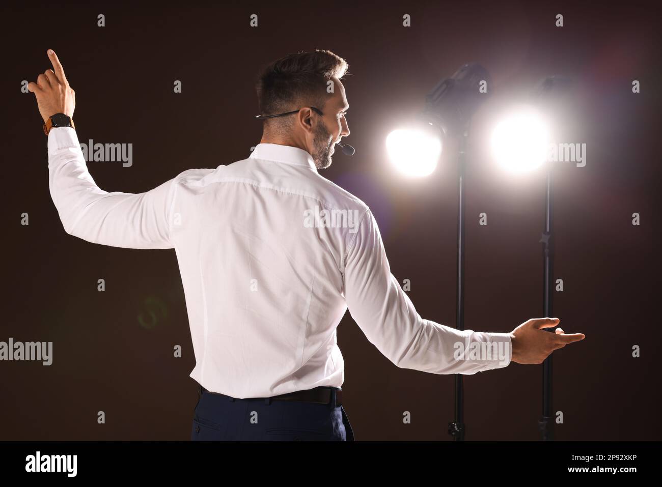 Motivational speaker with headset performing on stage, back view Stock ...