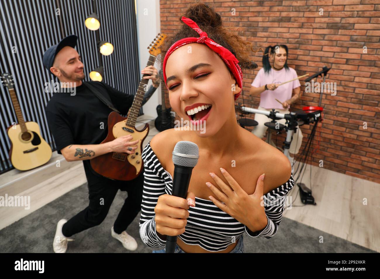 Music band performing in modern recording studio Stock Photo - Alamy