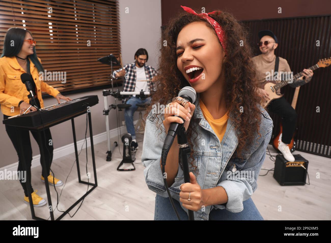 Music band performing in modern recording studio Stock Photo - Alamy