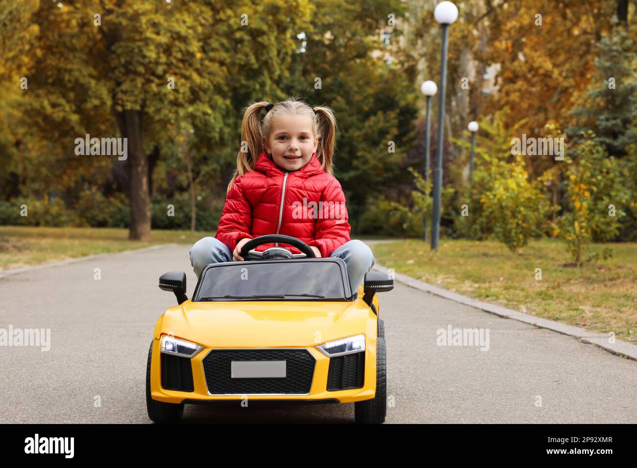 Cute little girl driving children's car outdoors Stock Photo - Alamy