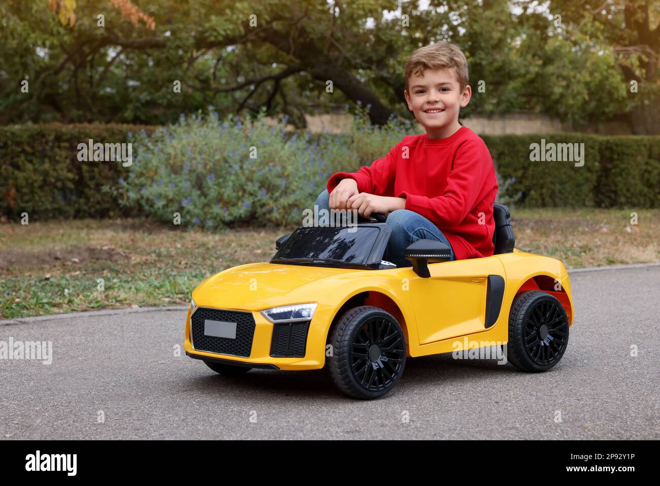 Cute little boy driving children's car outdoors Stock Photo - Alamy