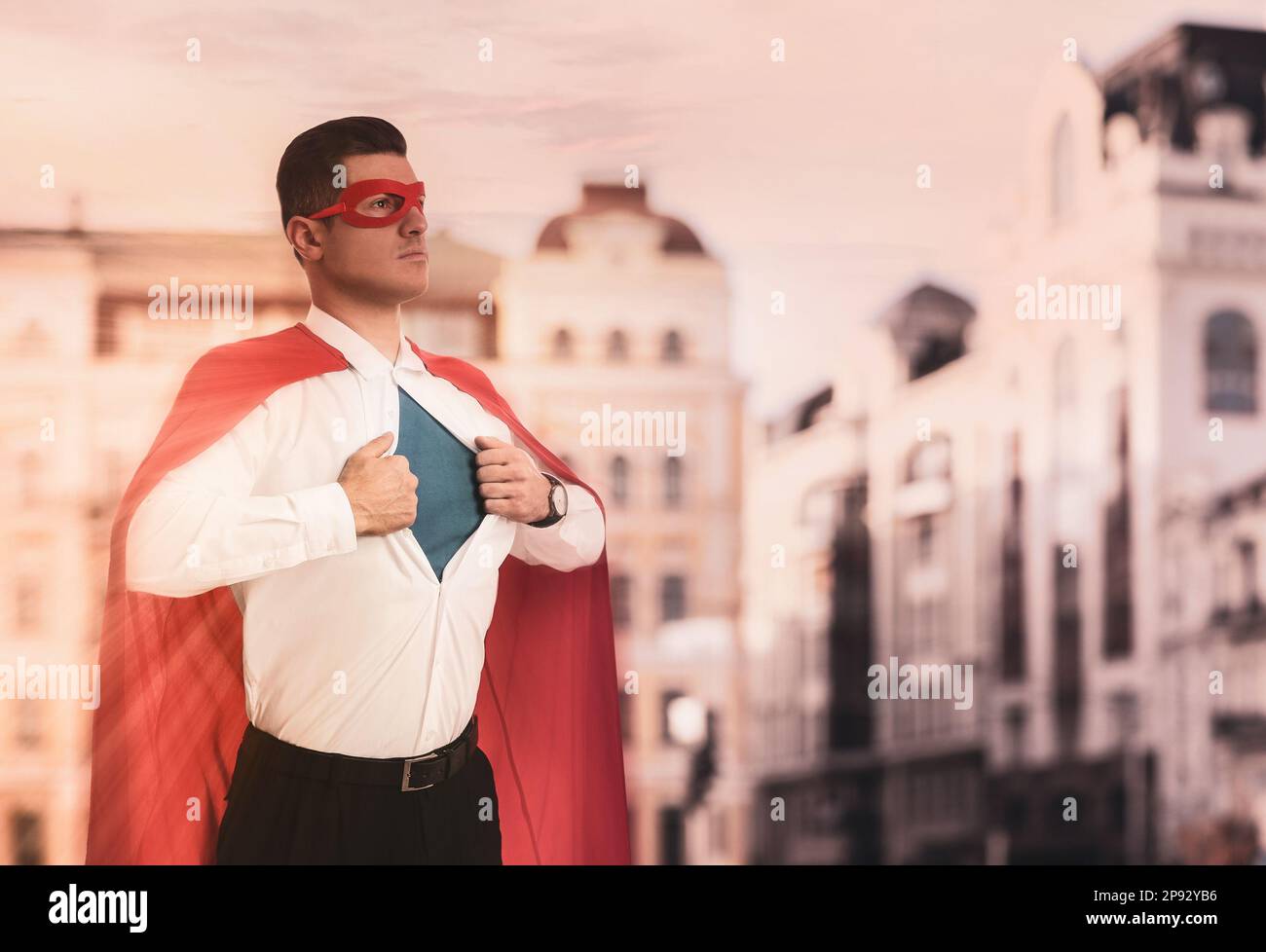 Businessman in superhero cape and mask taking shirt off against ...