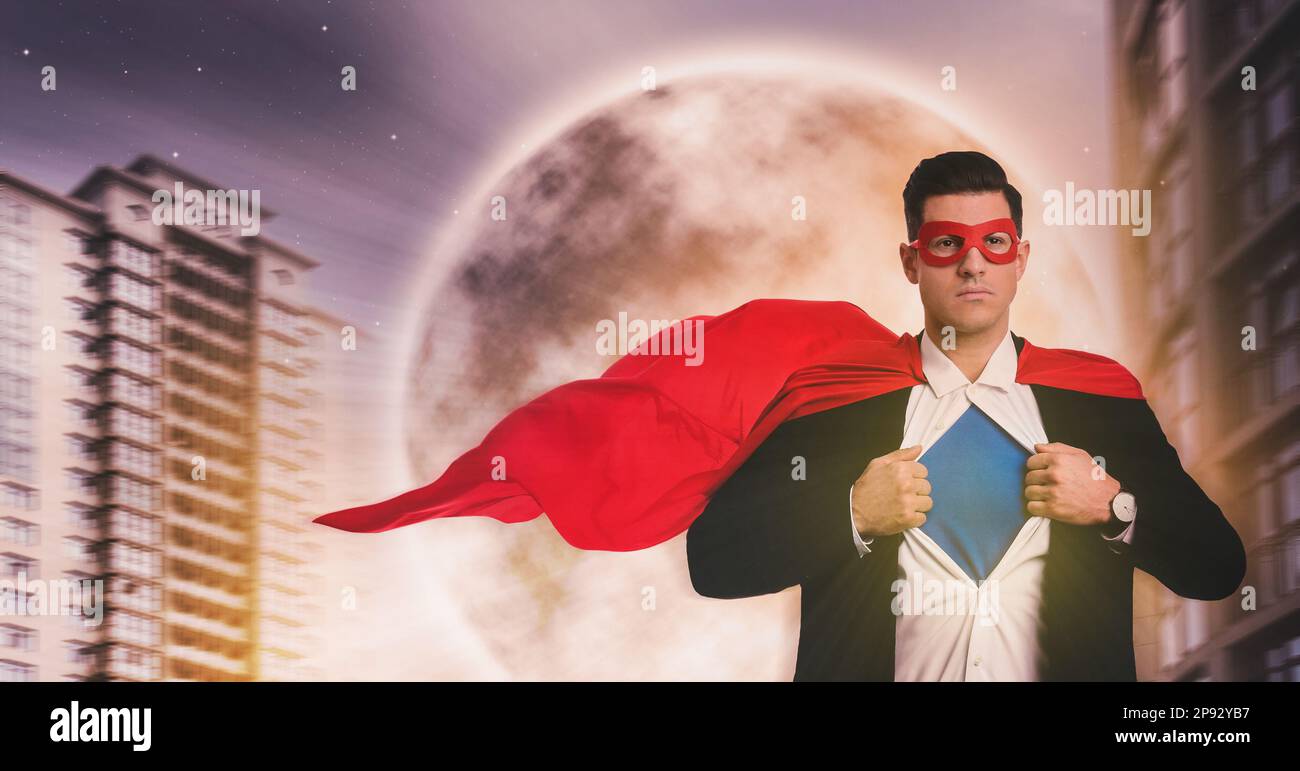 Businessman in superhero cape and mask taking suit off against ...