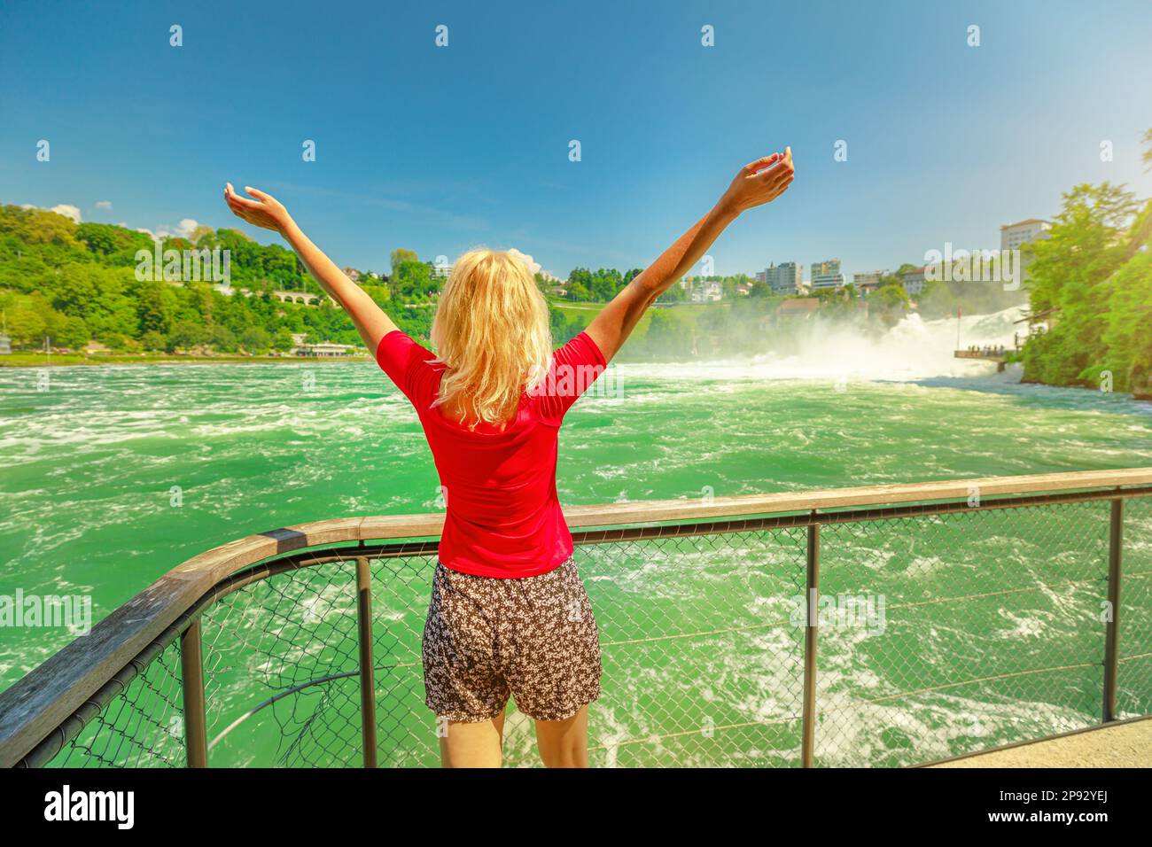 Girl with open arms under the Rheinfall waterfall of Switzerland. Rhine ...