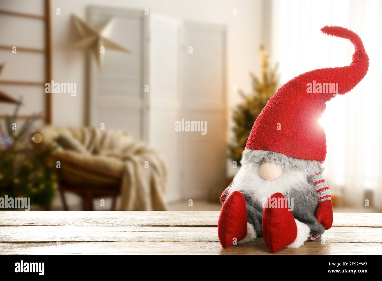 Funny Christmas gnome on wooden table in room with festive decorations ...