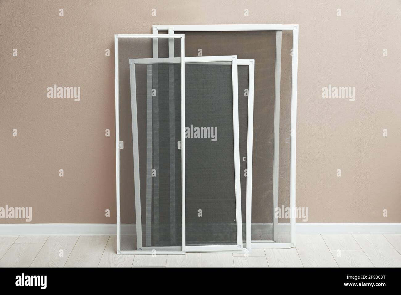 Set of window screens near beige wall indoors Stock Photo - Alamy