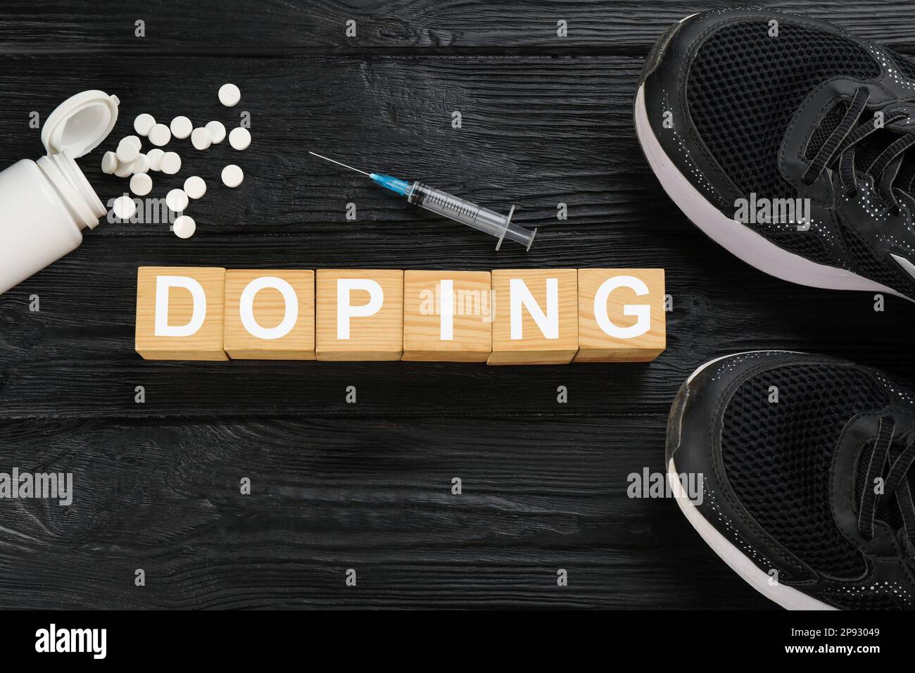 Cubes with word Doping, sport shoes and drugs on black wooden ...