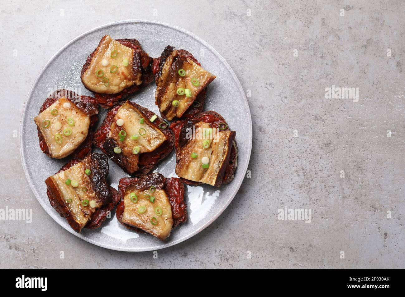 Tasty sandwiches with fried pork fatback slices on grey table, top view ...