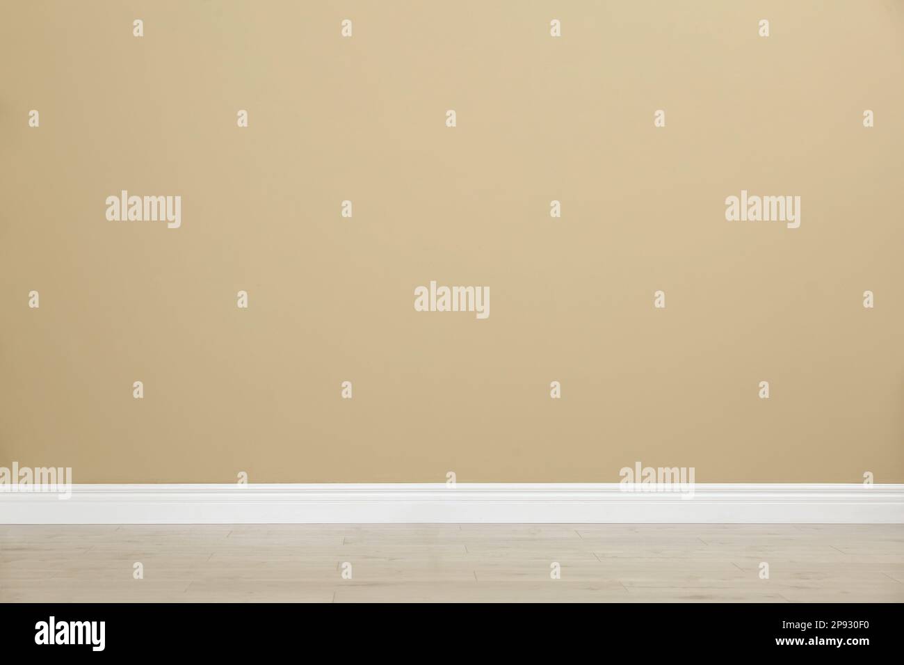 Empty room with beige wall and wooden floor Stock Photo - Alamy
