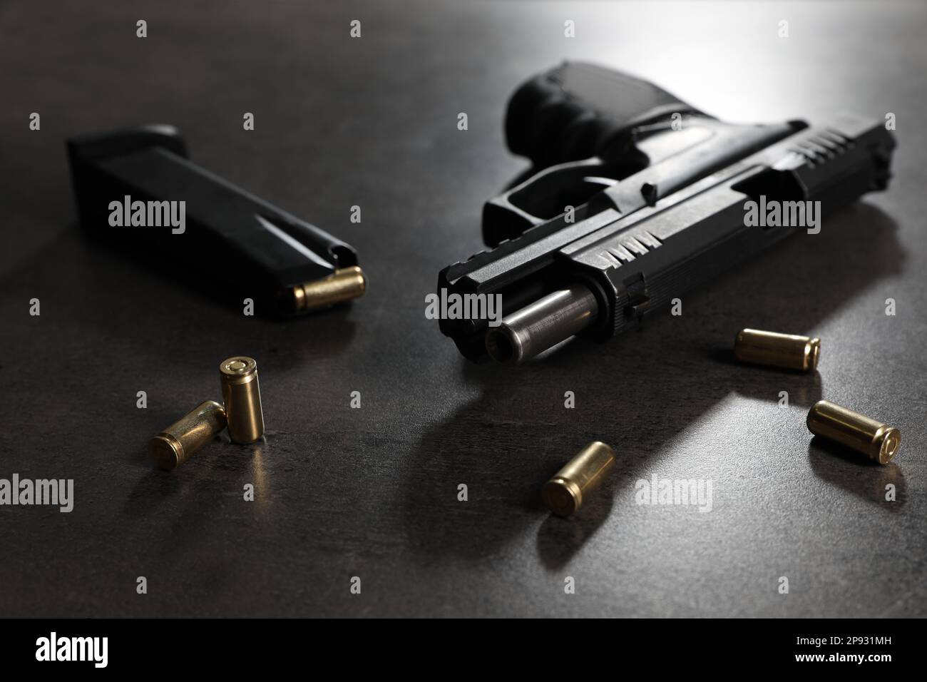 Handgun, magazine and bullets on grey table Stock Photo - Alamy