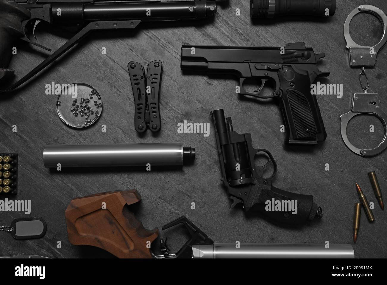 Flat lay composition with different guns on dark table Stock Photo - Alamy