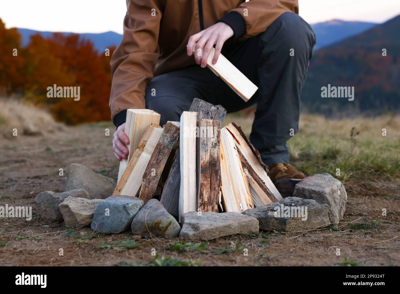 Traveler making bonfire with dry wood outdoors, closeup Stock Photo - Alamy
