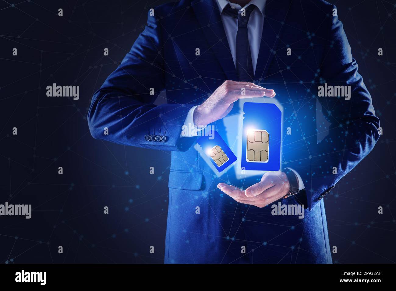 Man demonstrating SIM cards of different sizes on dark background ...