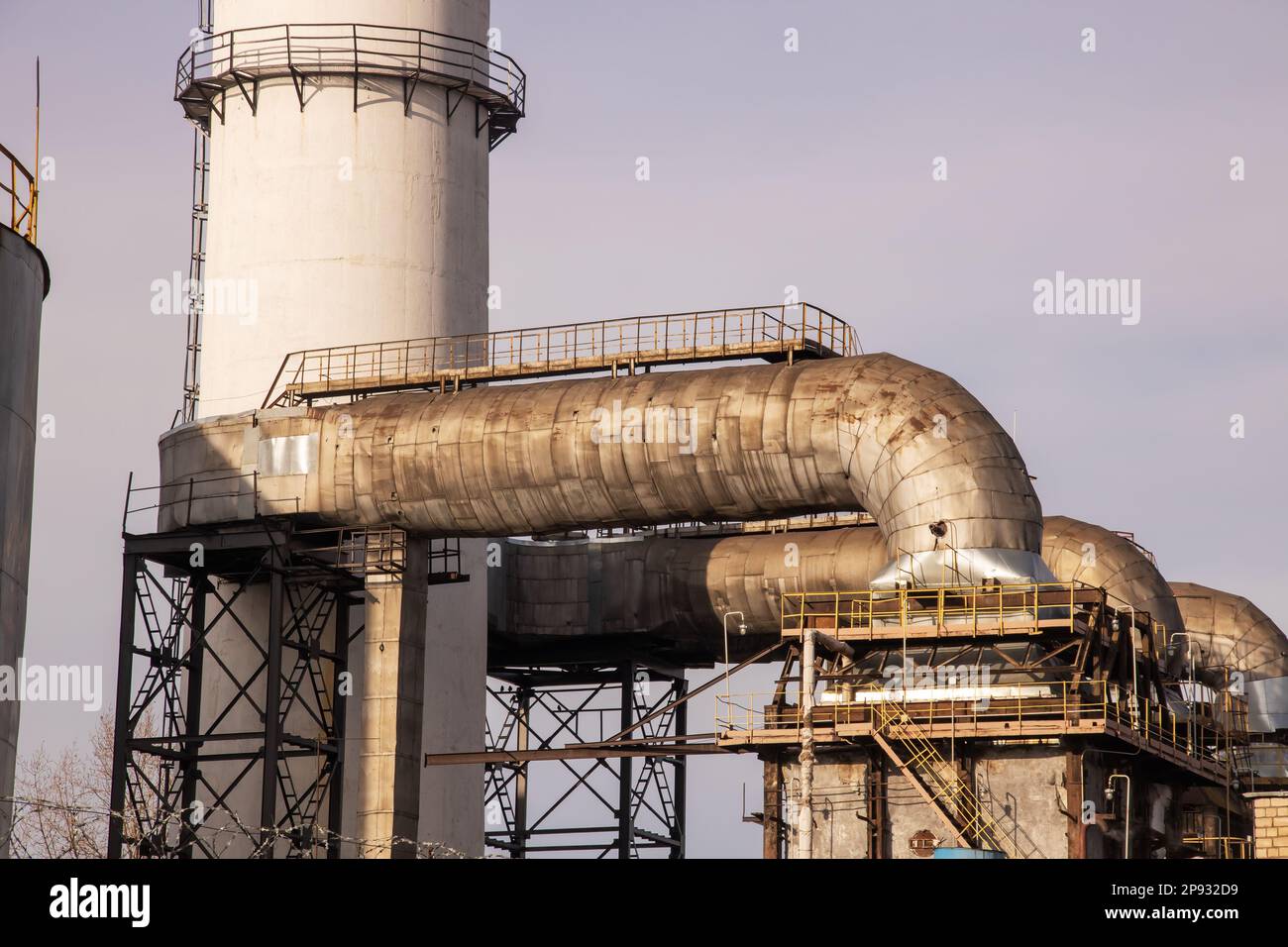 Large plant pipes and ladders on blue sky background close up Stock ...