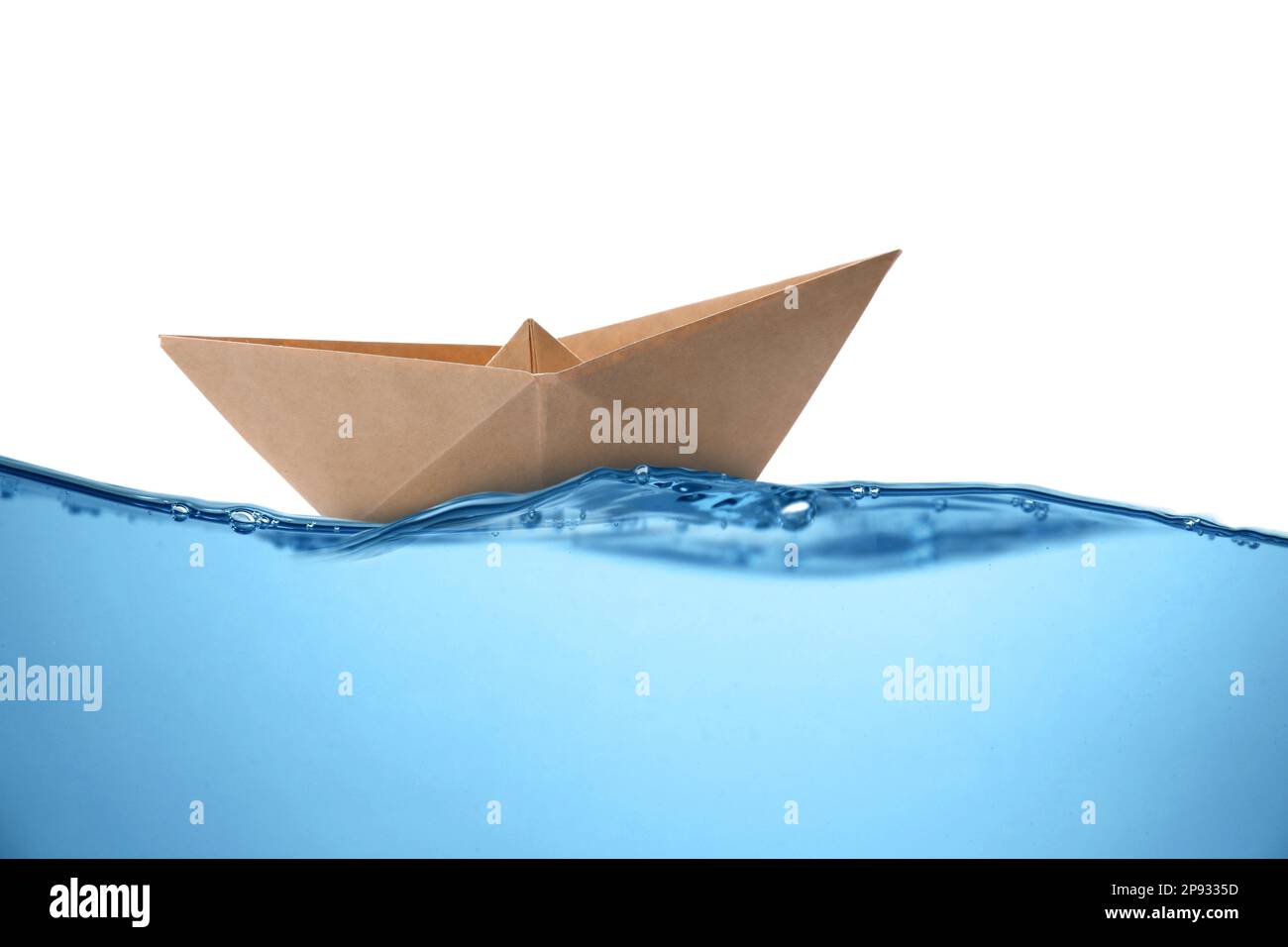 Handmade kraft paper boat floating on clear water against white ...